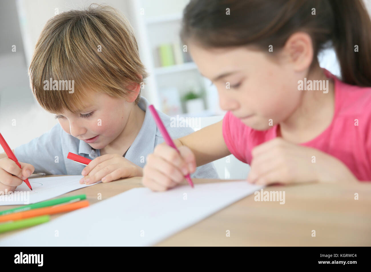 School kids sitting at table and writing on paper Stock Photo - Alamy