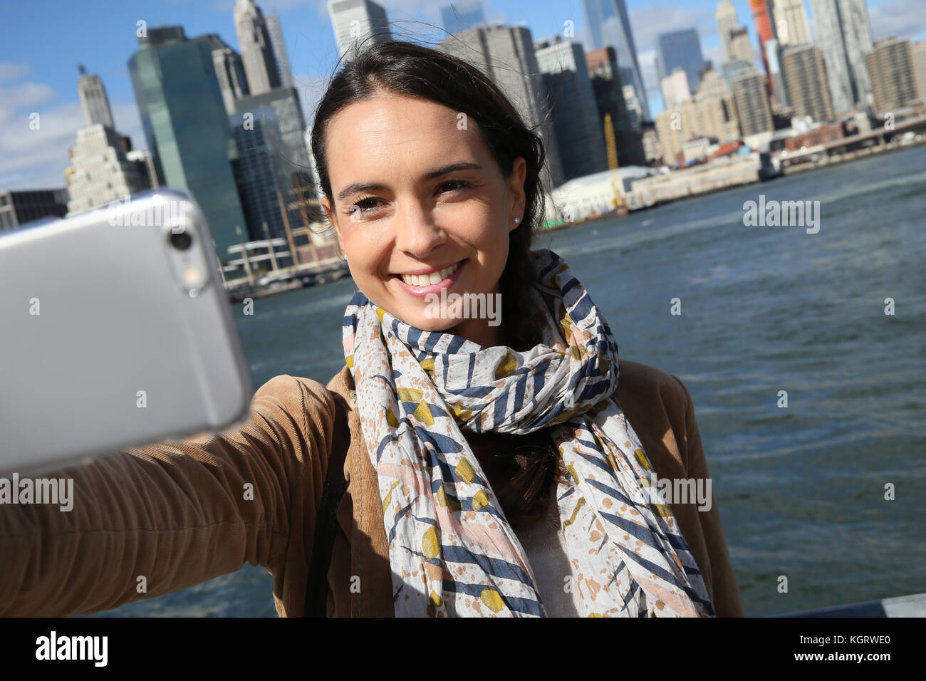 Brunette girl making selfy with Manhattan in background Stock Photo - Alamy