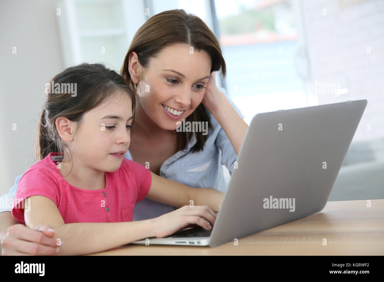 Mother and daughter doing homework on laptop Stock Photo - Alamy