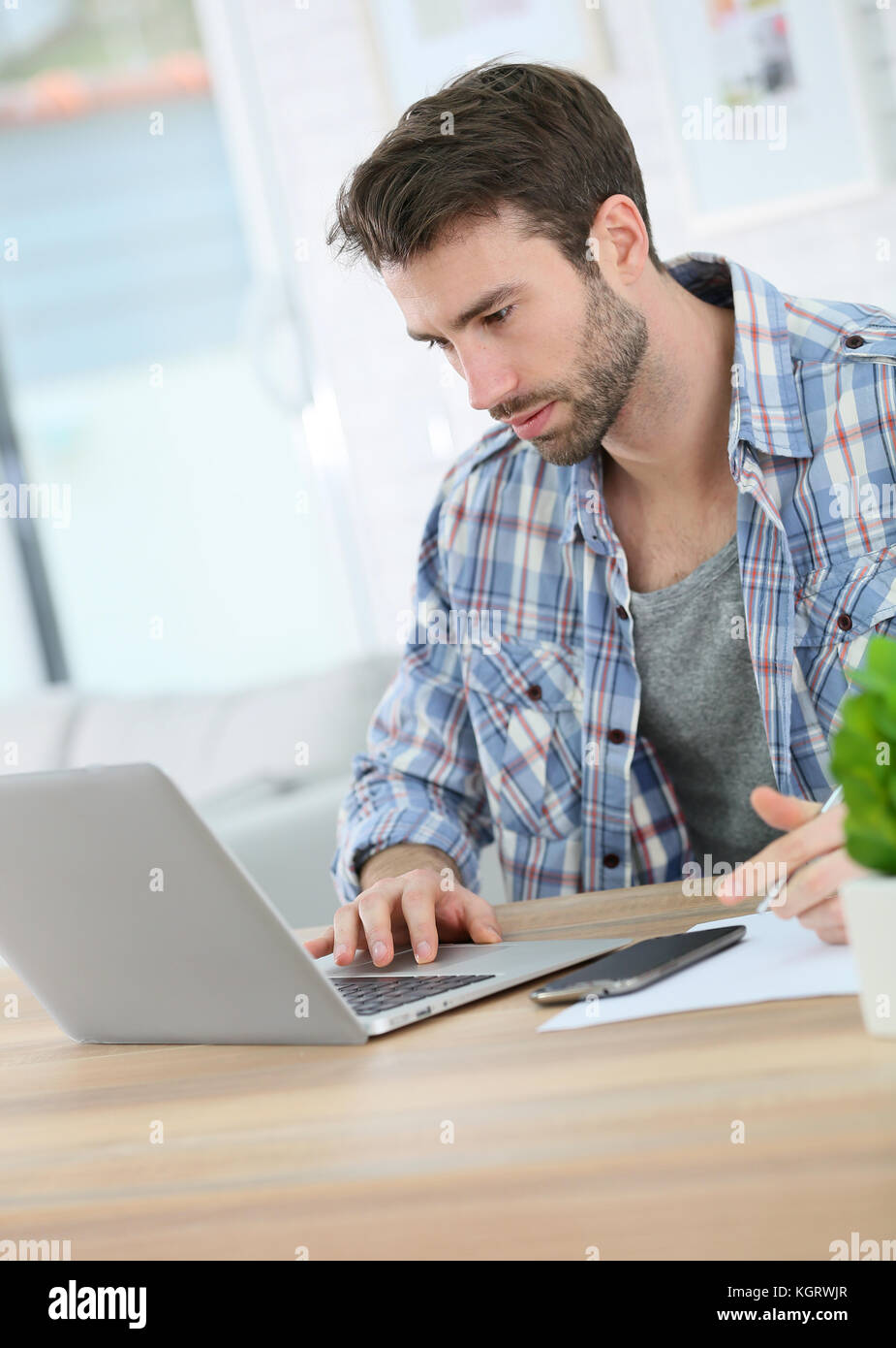 Man in office working on laptop computer Stock Photo - Alamy