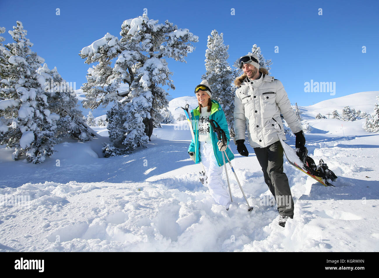 Skiers walking in snow track Stock Photo - Alamy