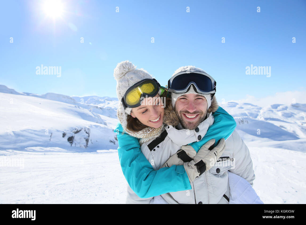 Man holding girlfriend on his back at the top of mountain Stock Photo ...