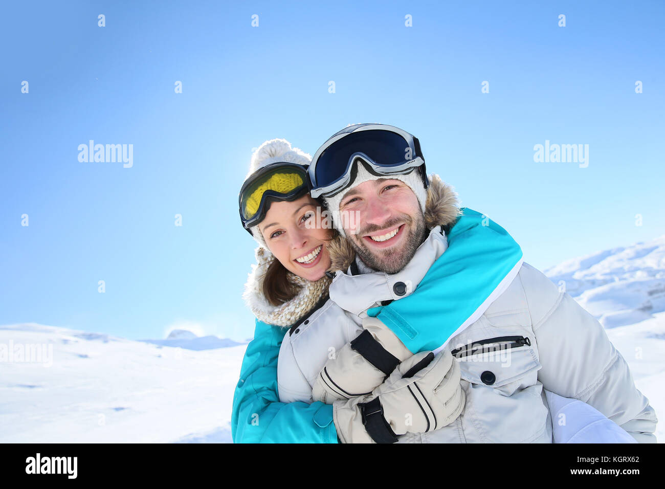 Man holding girlfriend on his back at the top of mountain Stock Photo ...