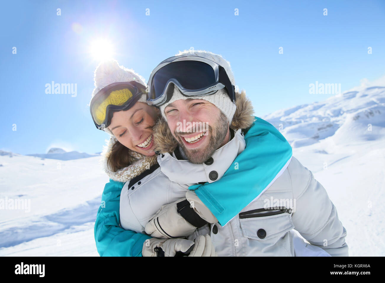 Man holding girlfriend on his back at the top of mountain Stock Photo ...
