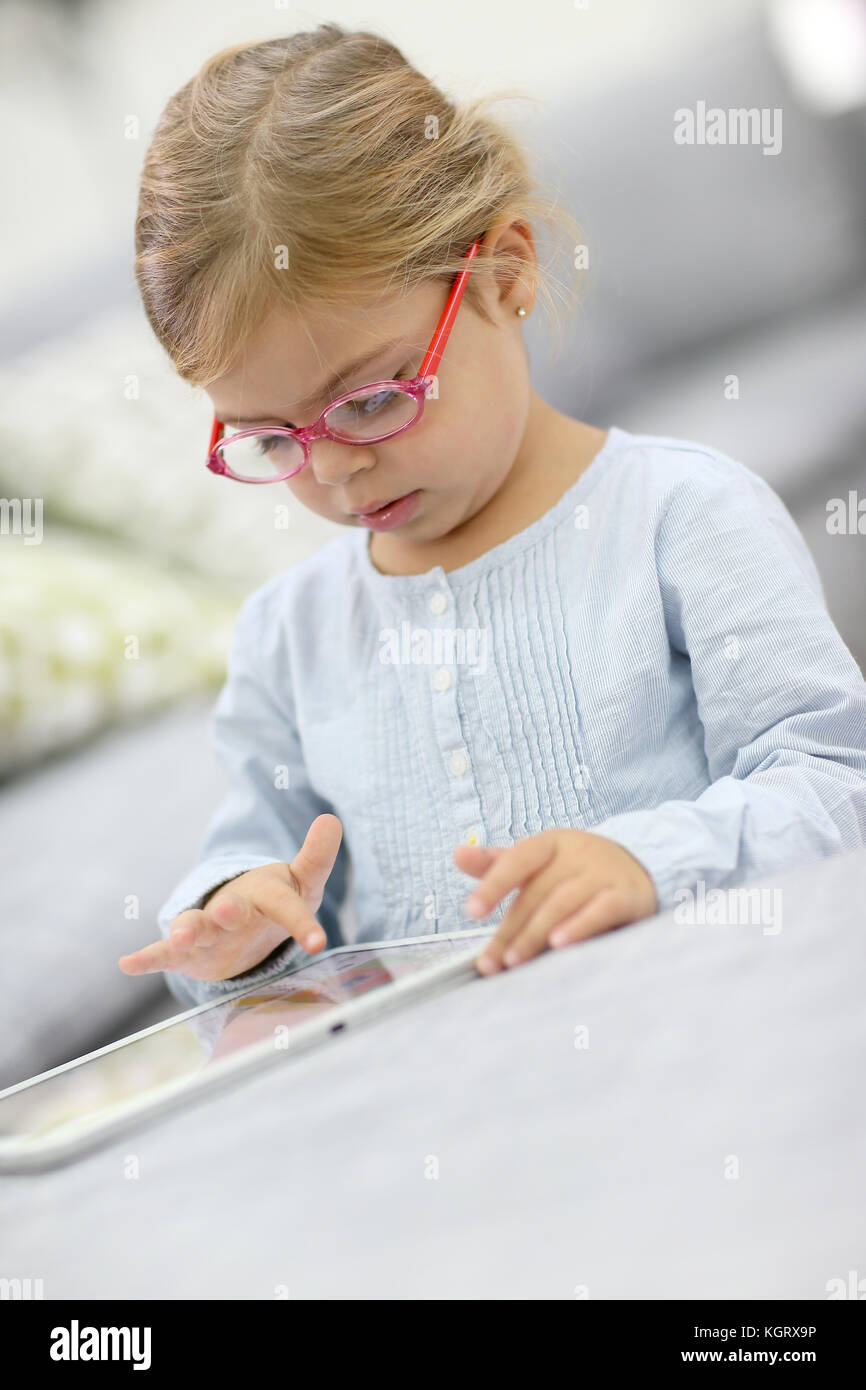 Cute little girl playing with digital tablet Stock Photo - Alamy
