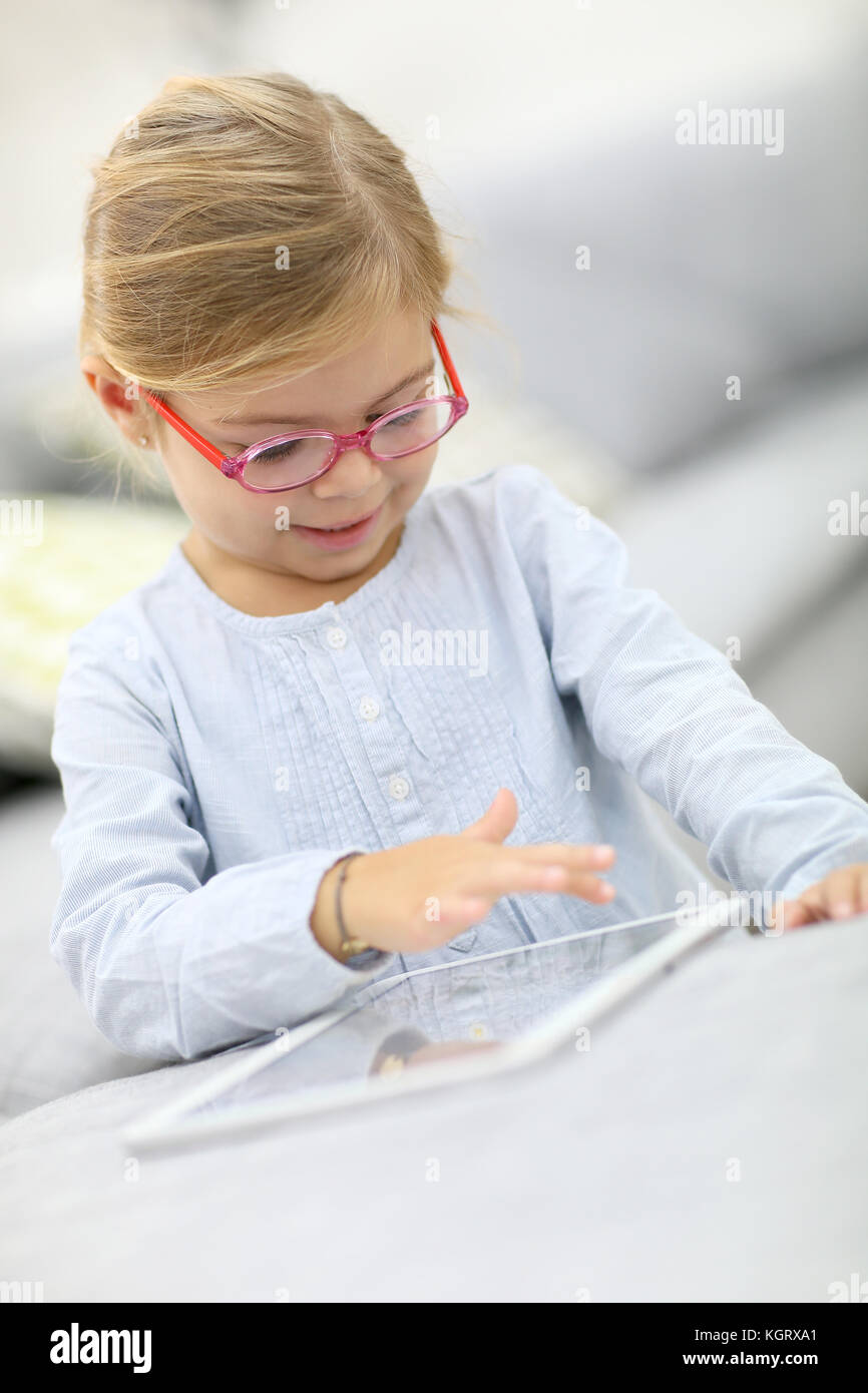 Cute little girl playing with digital tablet Stock Photo - Alamy