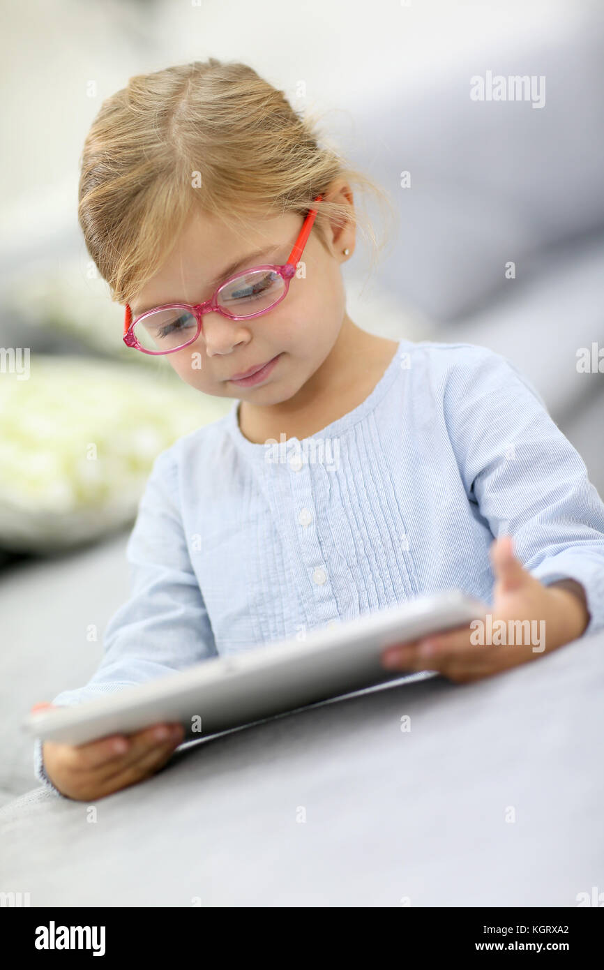 Cute little girl playing with digital tablet Stock Photo - Alamy