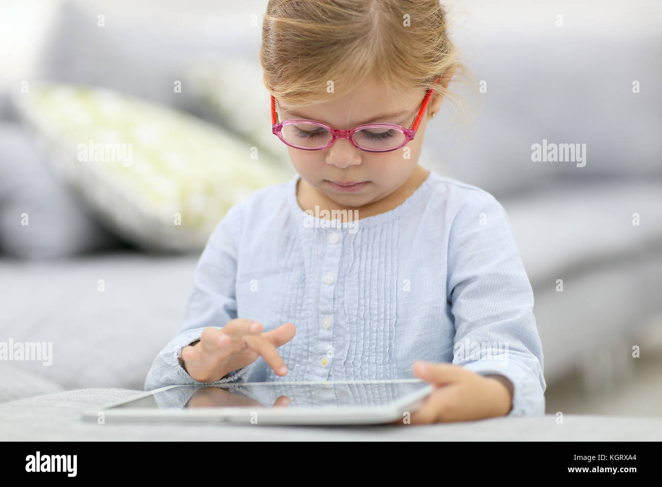Cute little girl playing with digital tablet Stock Photo - Alamy