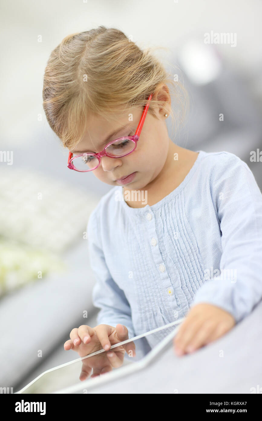 Cute little girl playing with digital tablet Stock Photo - Alamy