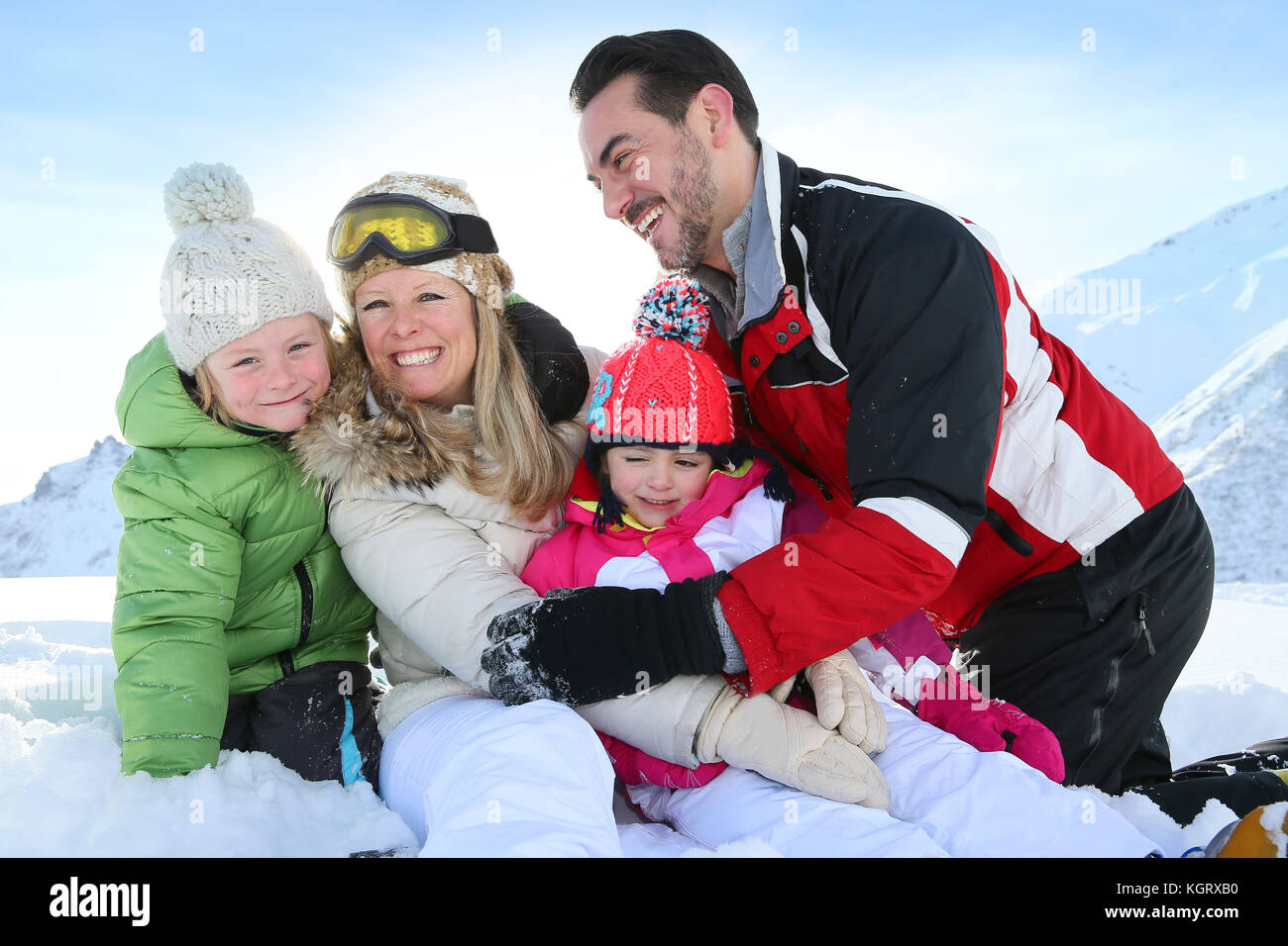 Cheerful family sitting in snow Stock Photo - Alamy