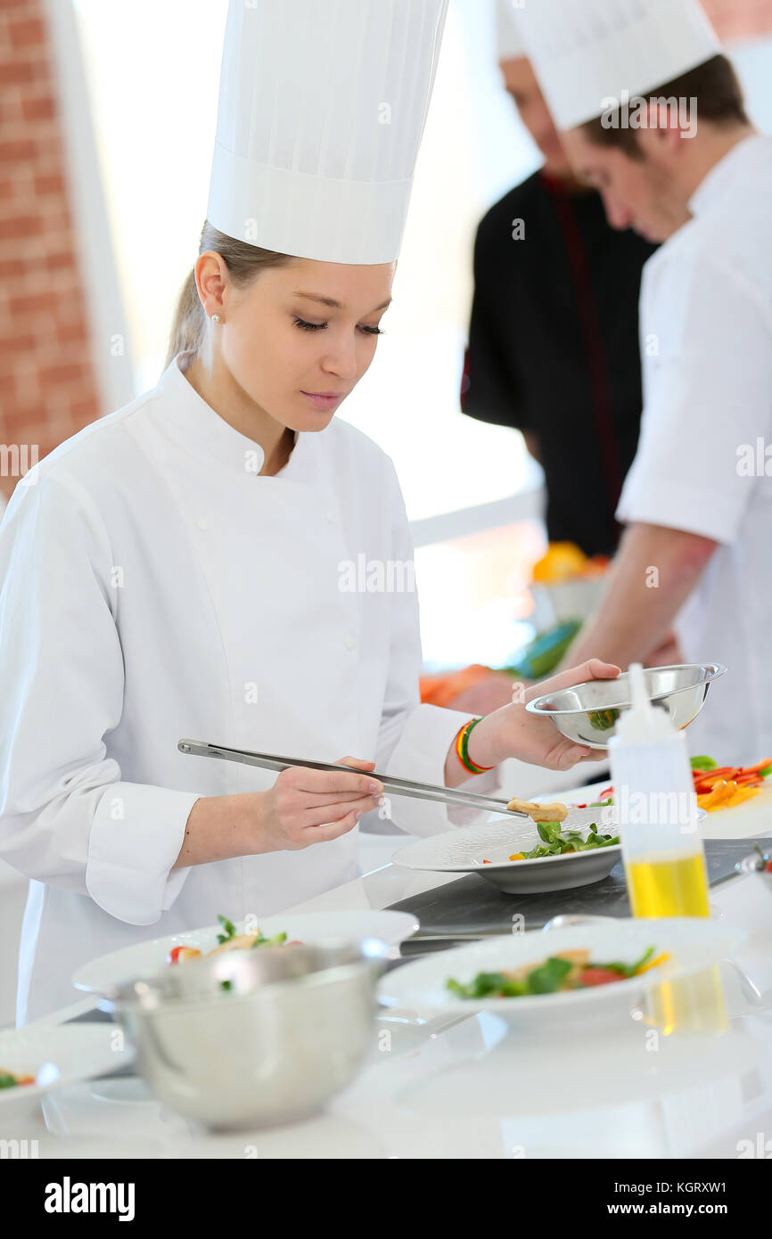 Girl in cooking training class preparing dish Stock Photo - Alamy