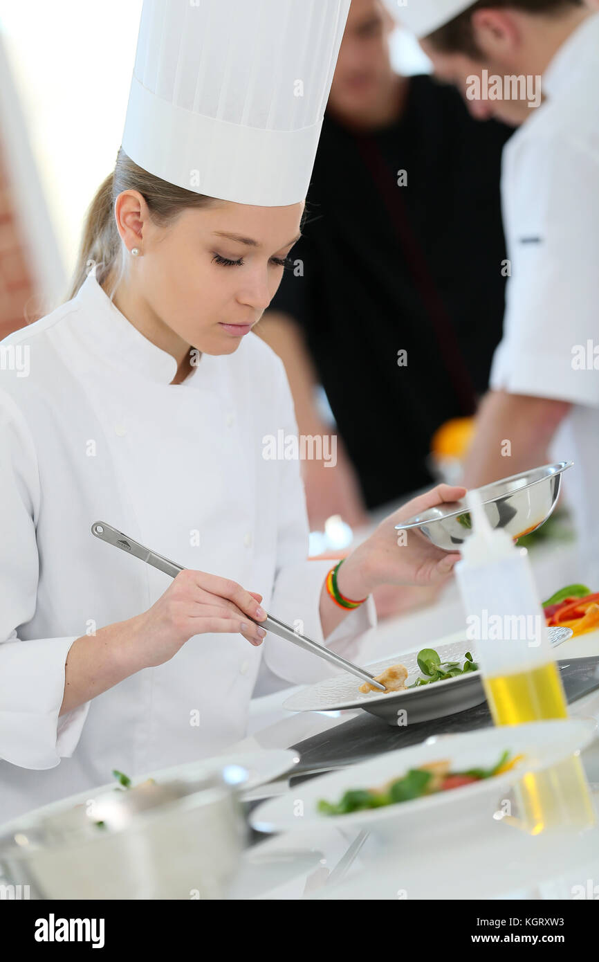Girl in cooking training class preparing dish Stock Photo - Alamy