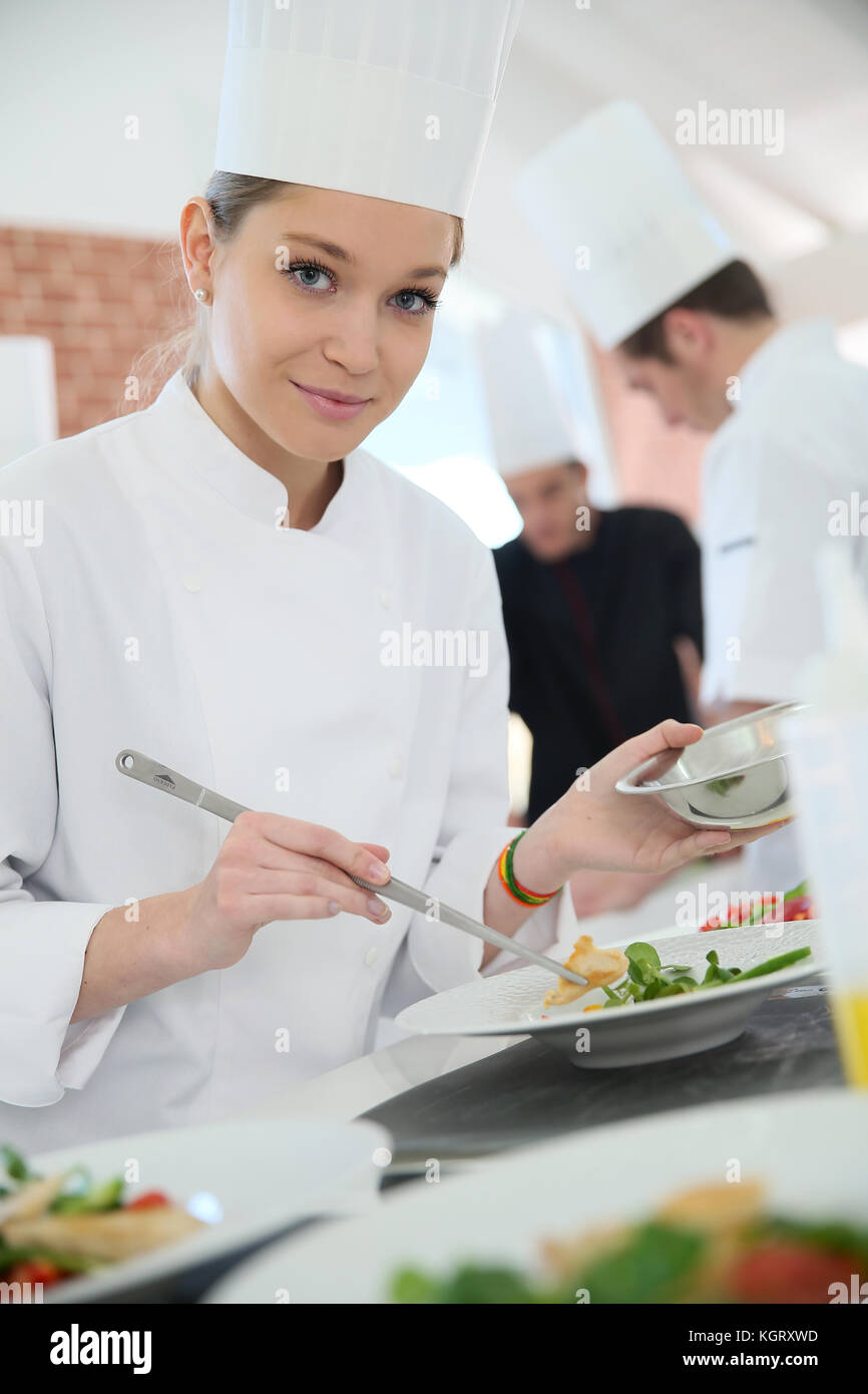 Girl in cooking training class preparing dish Stock Photo - Alamy
