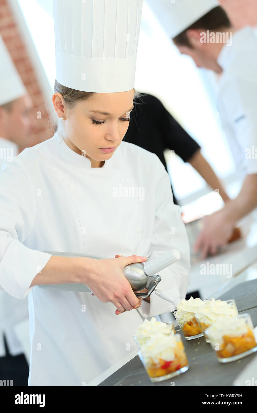 Pastry cook spreading whipped cream on dessert Stock Photo - Alamy