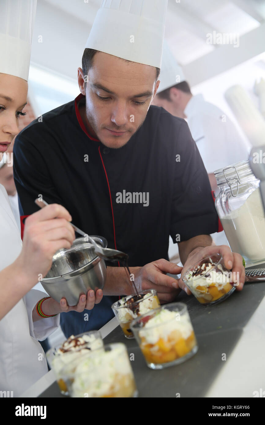 Chef with student in pastry making dessert Stock Photo - Alamy