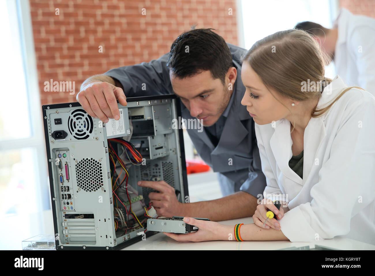 Teacher with student in technology repairing computer Stock Photo - Alamy