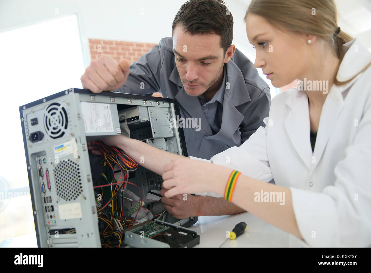 Teacher with student in technology repairing computer Stock Photo - Alamy