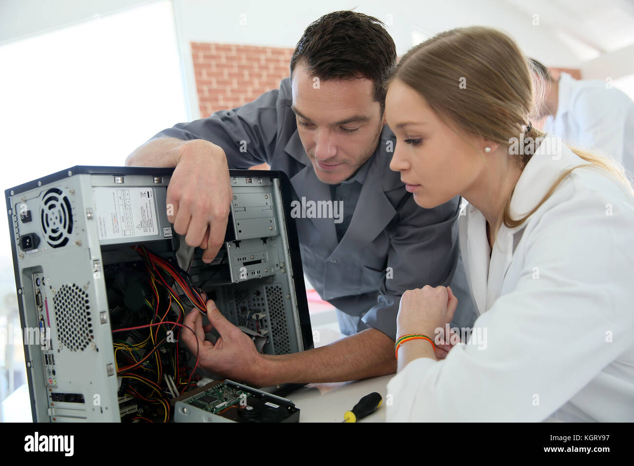 Teacher with student in technology repairing computer Stock Photo - Alamy