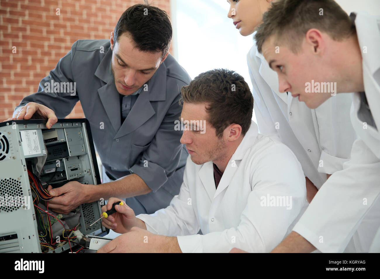 Students in computing class with teacher fixing hardware Stock Photo ...