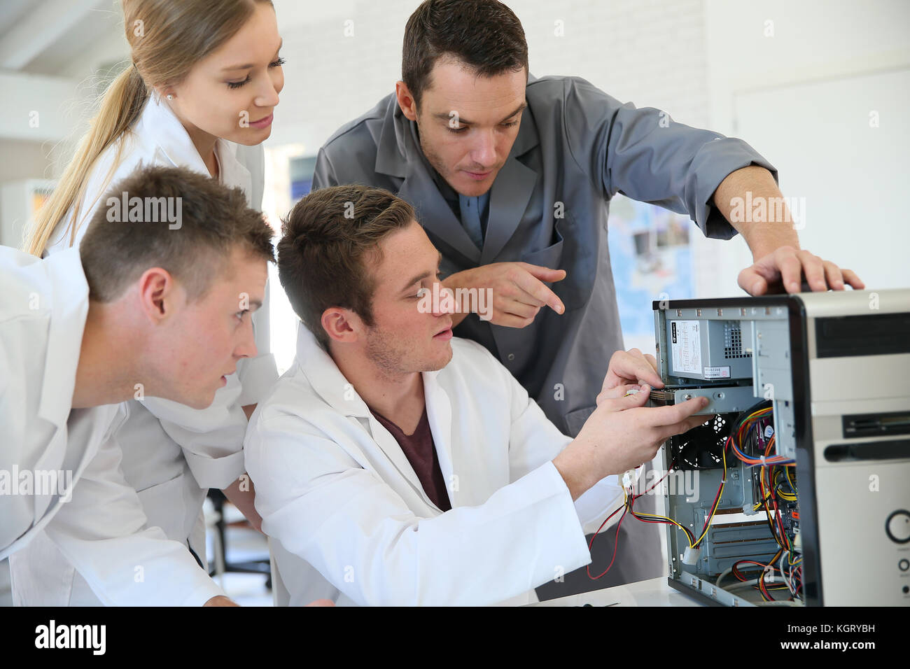 Students in computing class with teacher fixing hardware Stock Photo ...