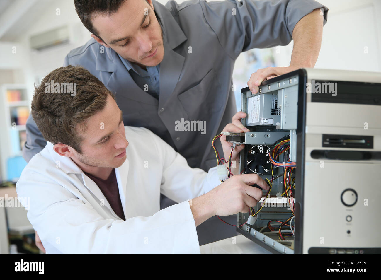 Young adults fixing computer hardware in technology school Stock Photo ...