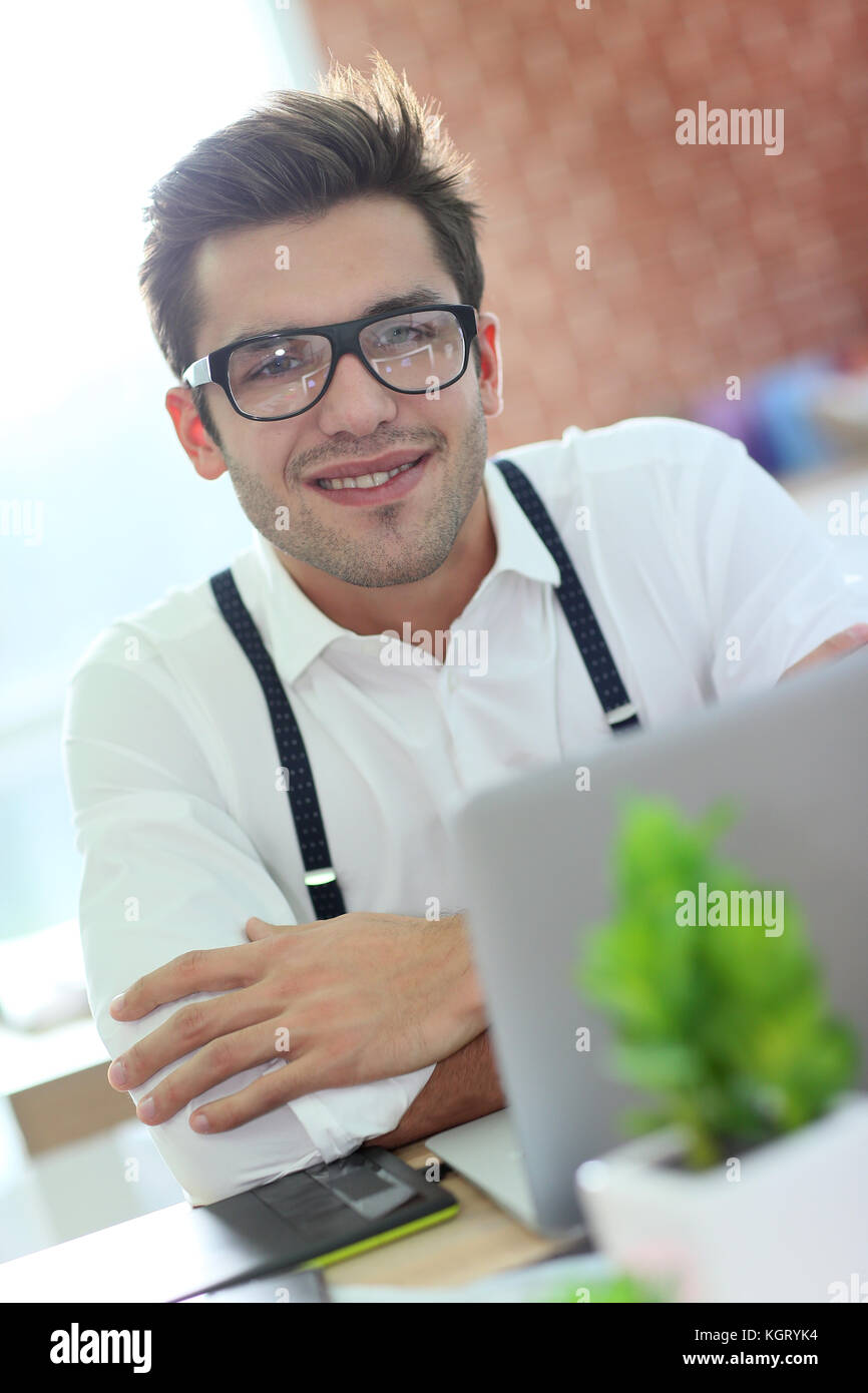 Trendy young man working in office with laptop Stock Photo - Alamy