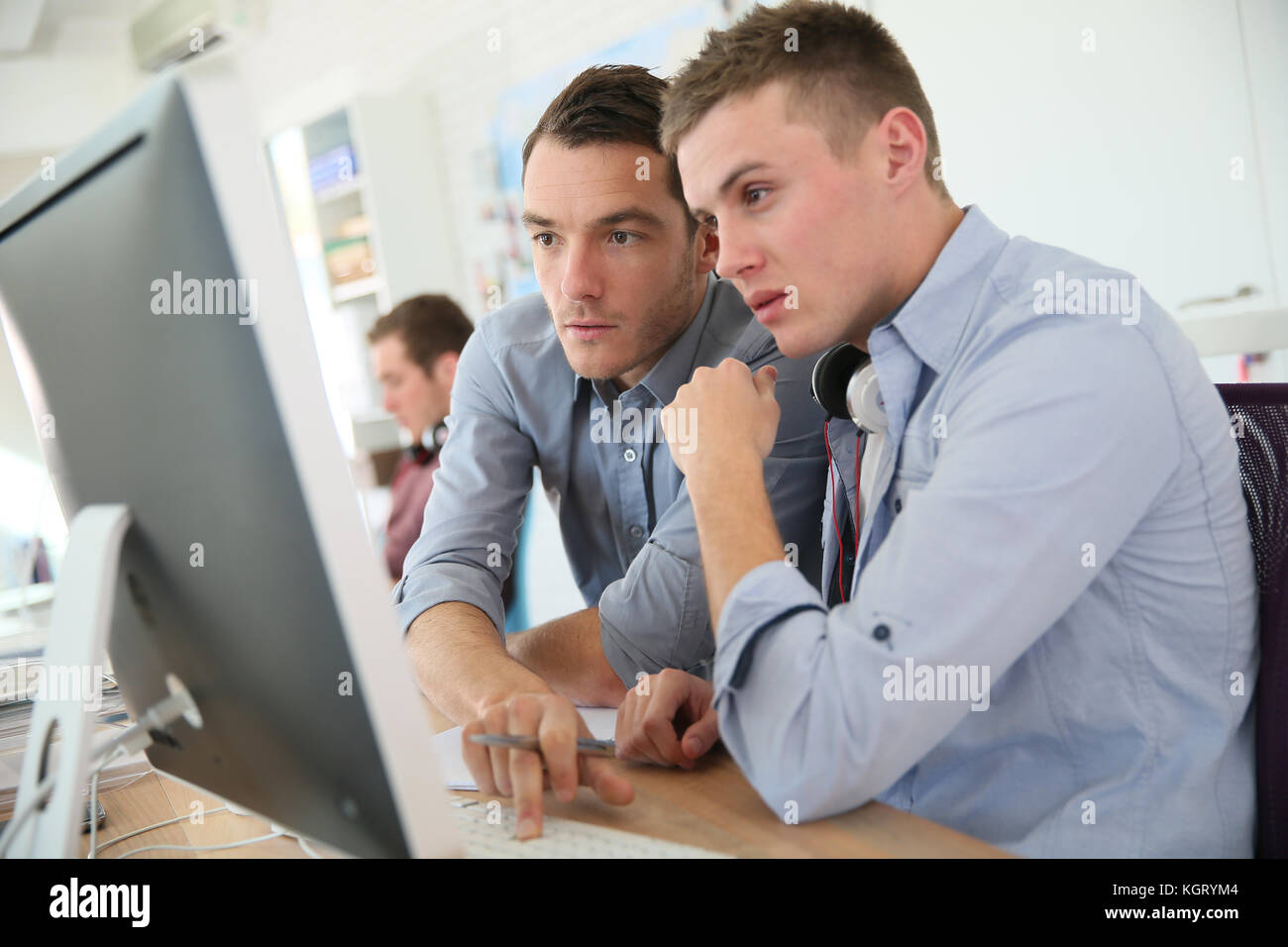 Teacher with student working on desktop Stock Photo - Alamy