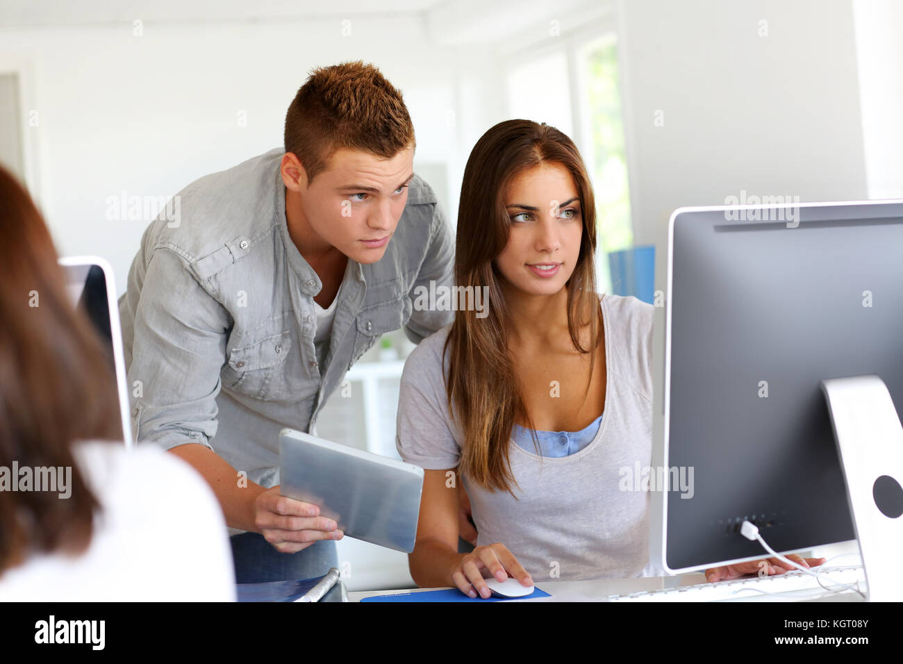 Trainees in office working on desktop computer Stock Photo - Alamy