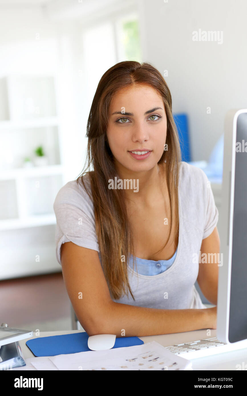 Beautiful office worker sitting in front of desktop Stock Photo - Alamy