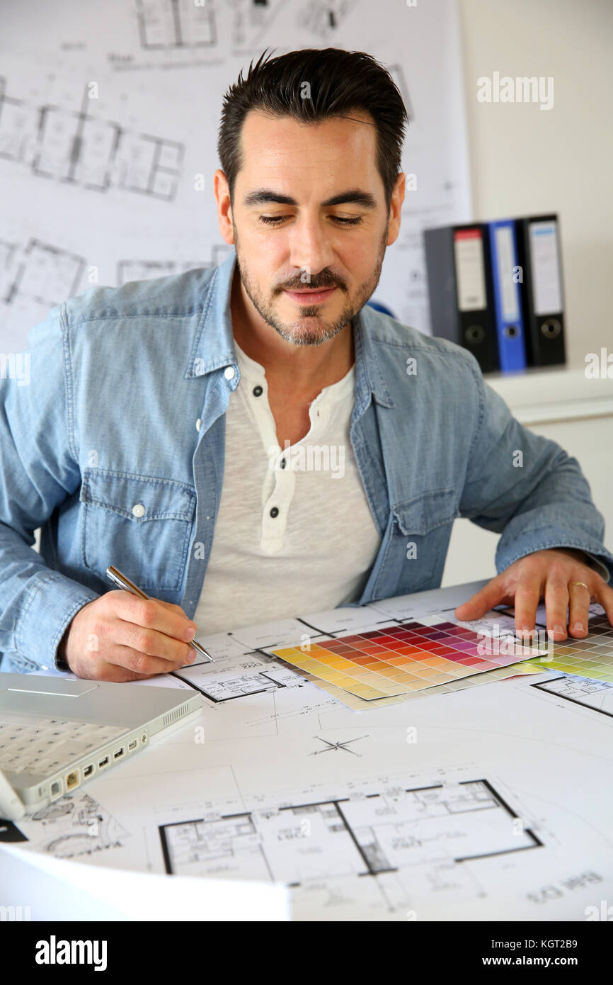 Architect working in office on blueprint Stock Photo - Alamy