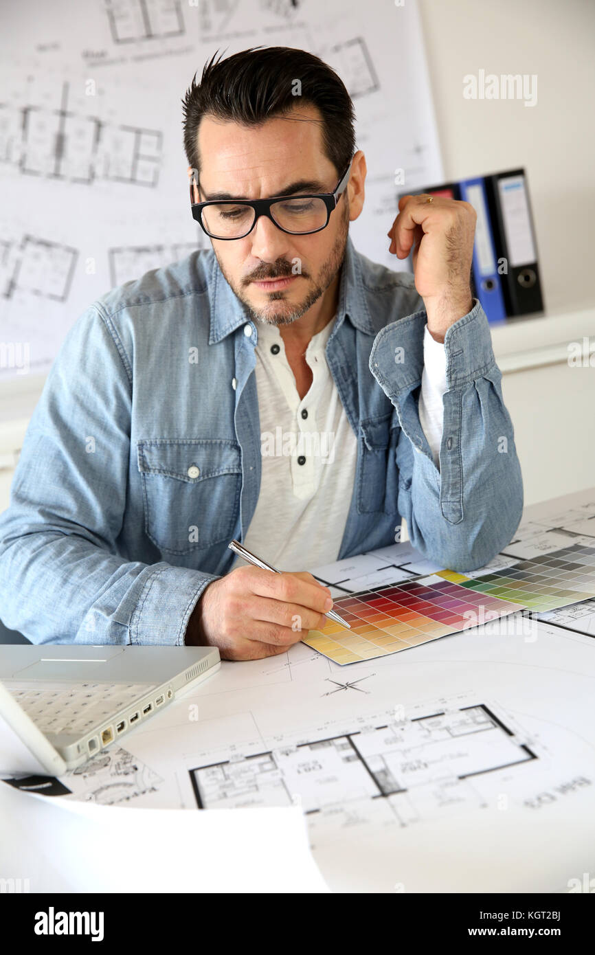 Architect working in office on blueprint Stock Photo - Alamy