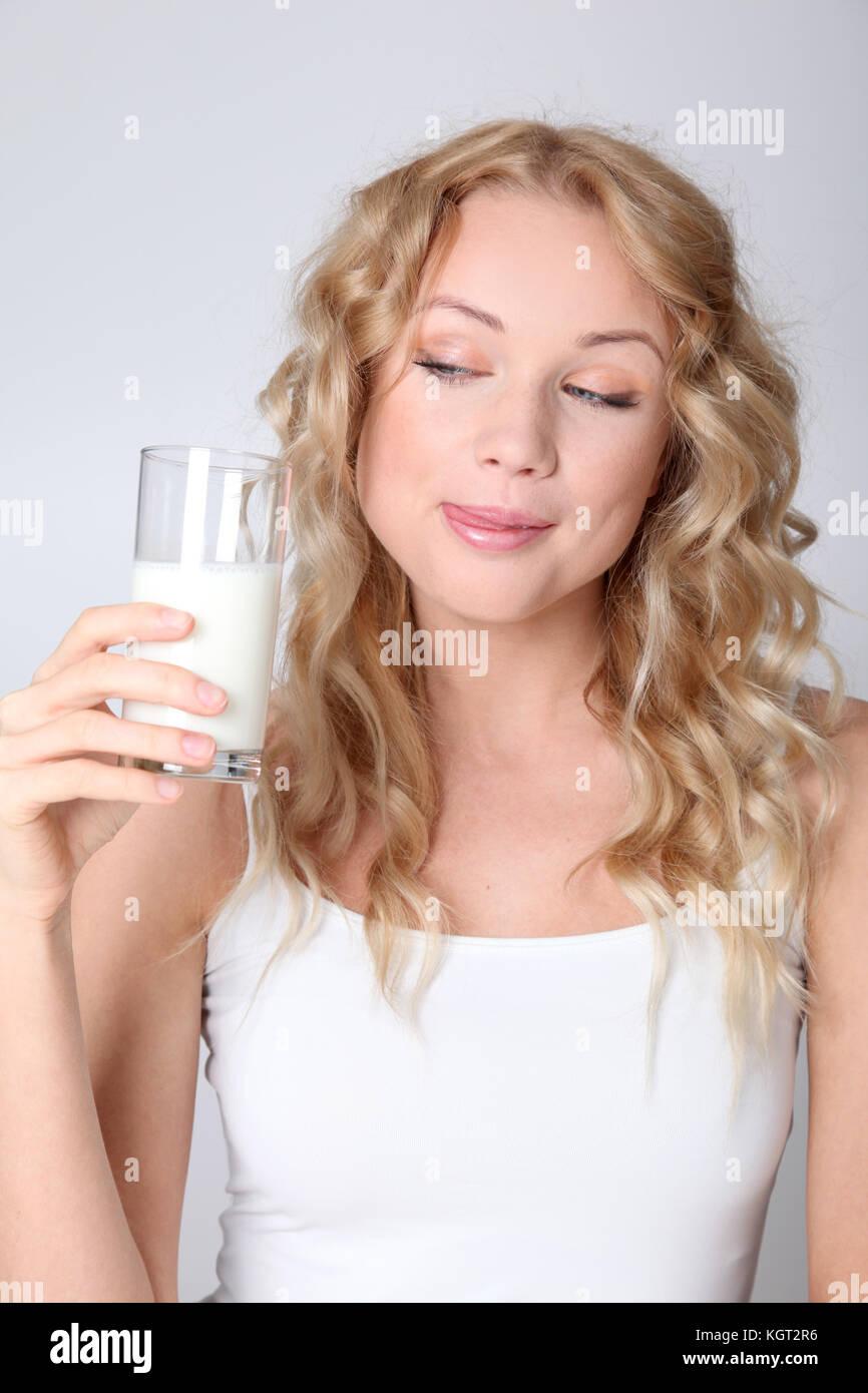 Blond woman drinking fresh milk Stock Photo - Alamy