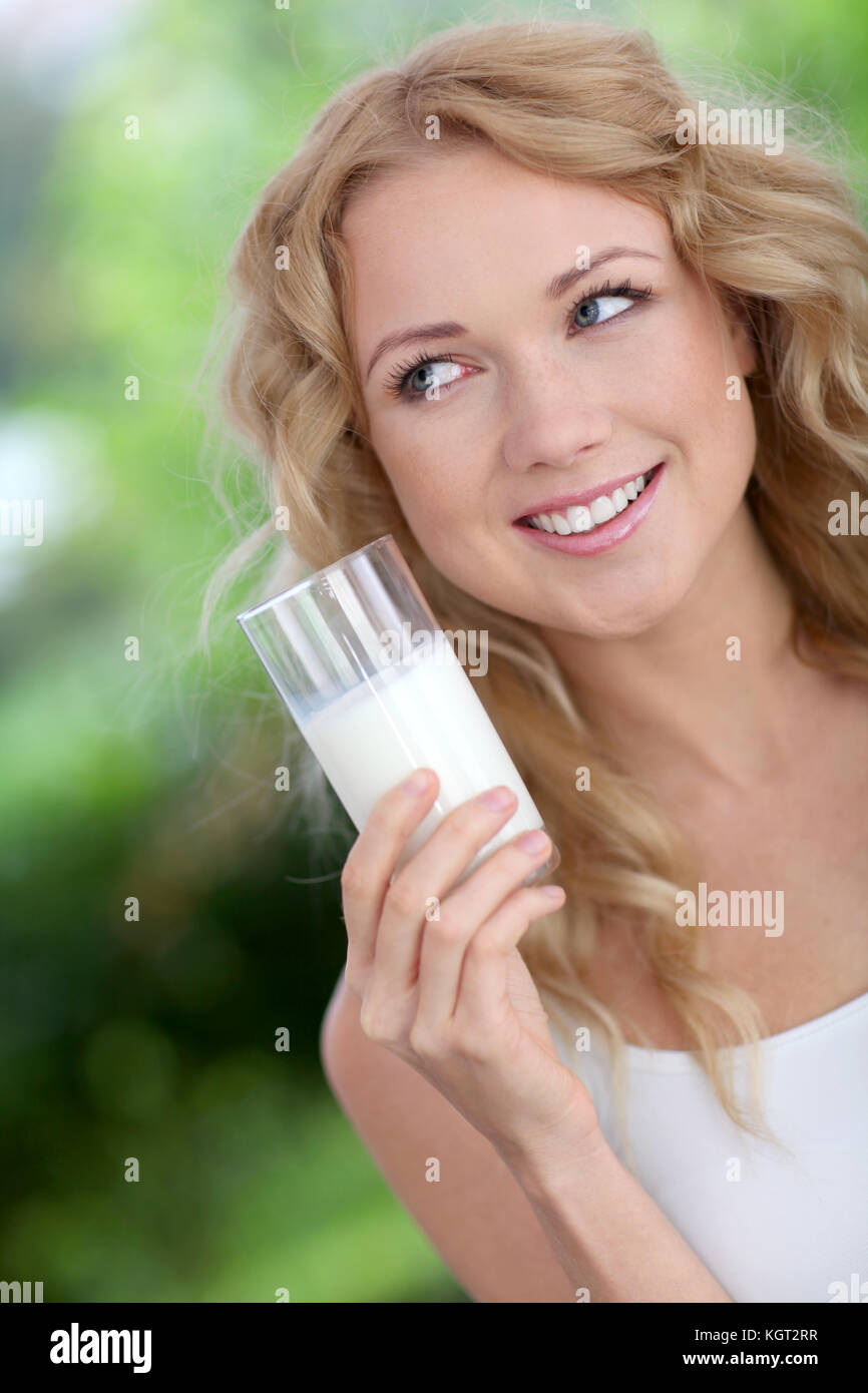 Blond woman drinking fresh milk Stock Photo - Alamy