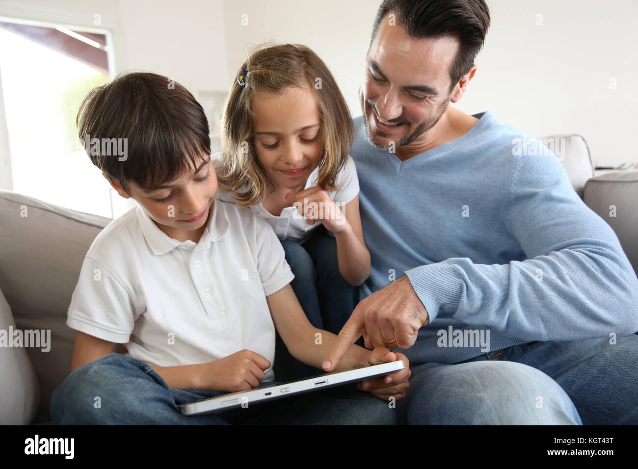 Children with daddy at home using digital tablet Stock Photo - Alamy