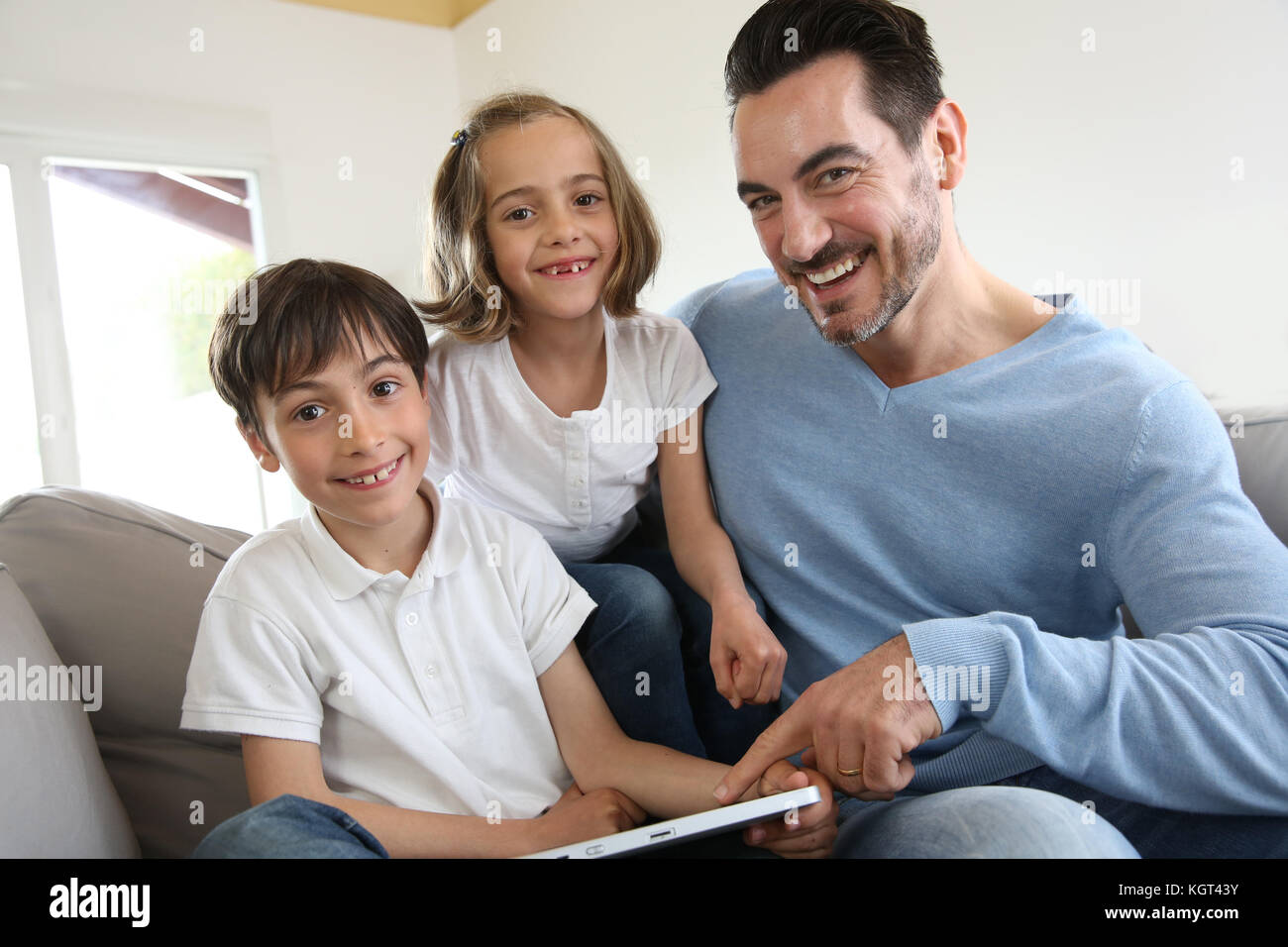 Children with daddy at home using digital tablet Stock Photo - Alamy