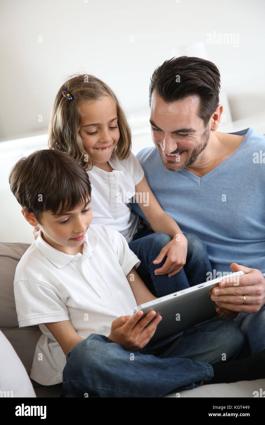 Children with daddy at home using digital tablet Stock Photo - Alamy