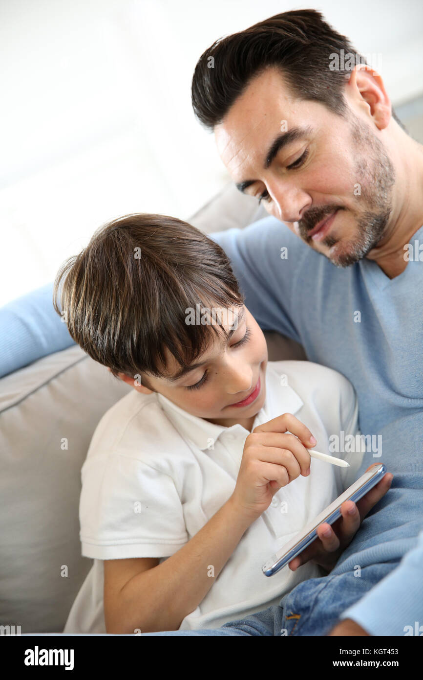 Little boy with dad playing with smartphone Stock Photo - Alamy