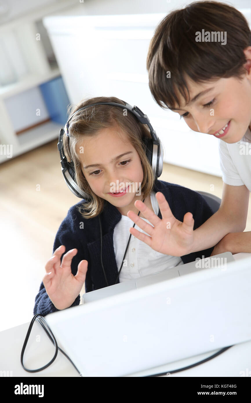 Portrait of kids waving at webcamera with laptop Stock Photo - Alamy