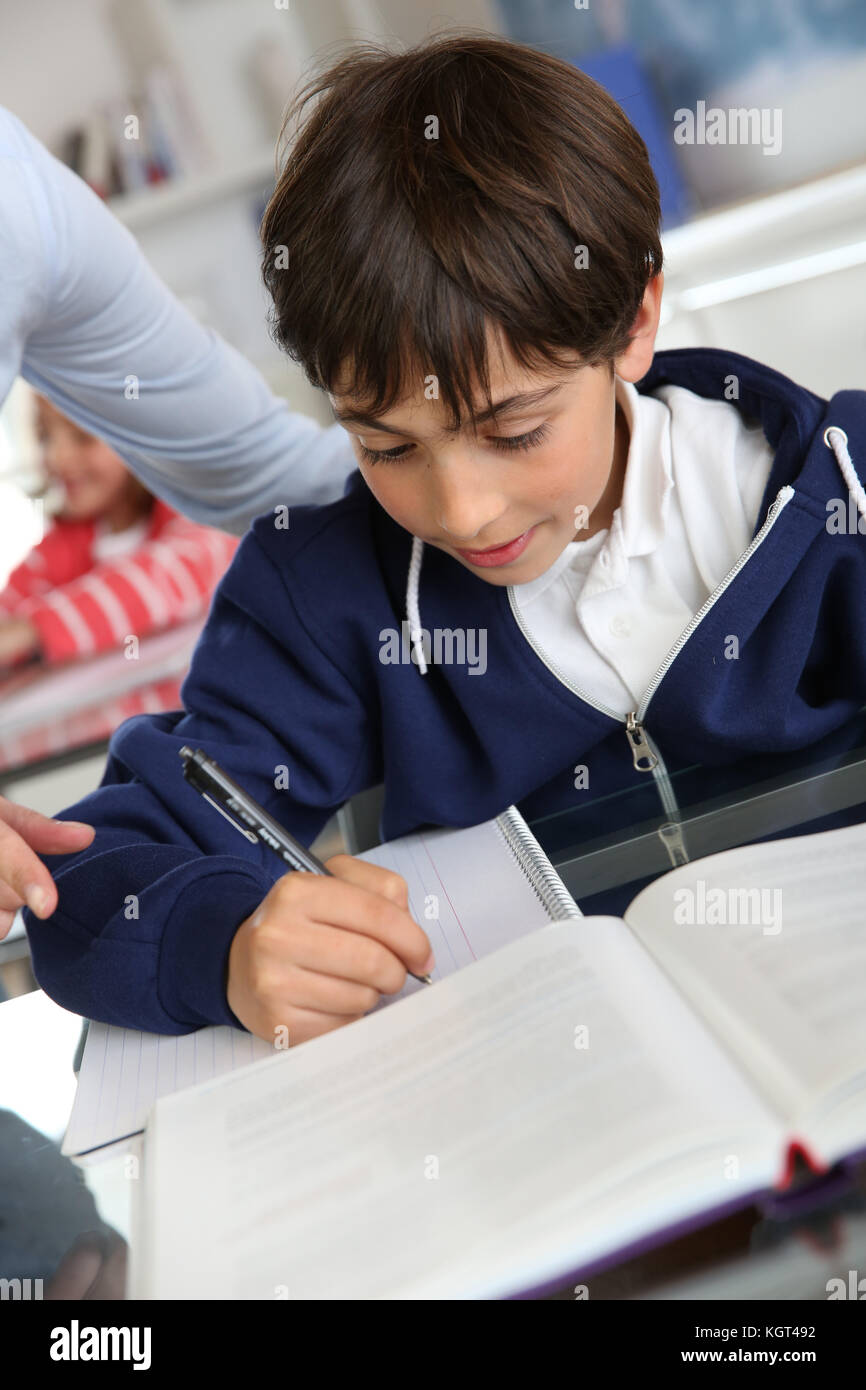 Young schoolboy sitting in classroom Stock Photo - Alamy