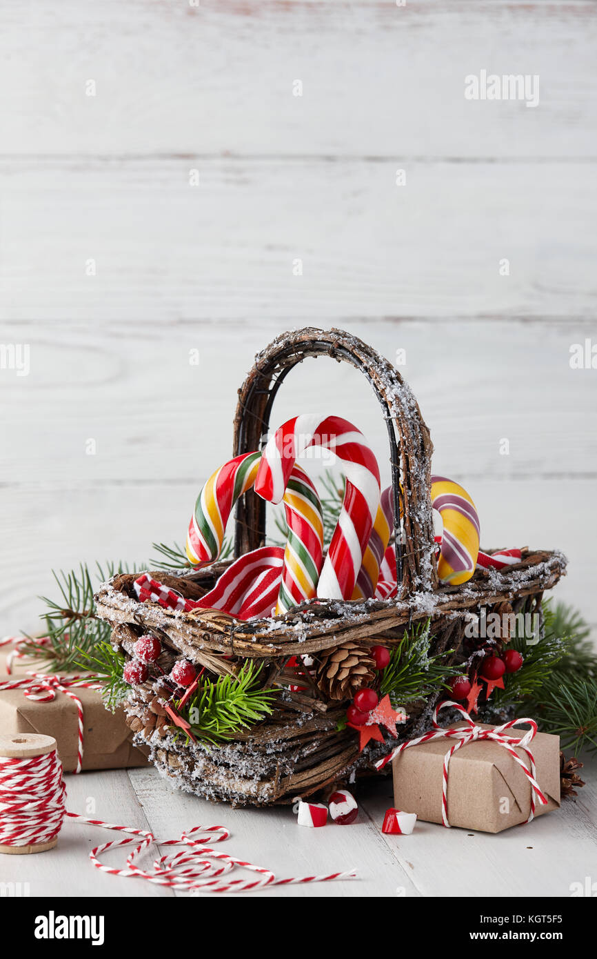 Christmas basket with candy canes on white planks Stock Photo - Alamy