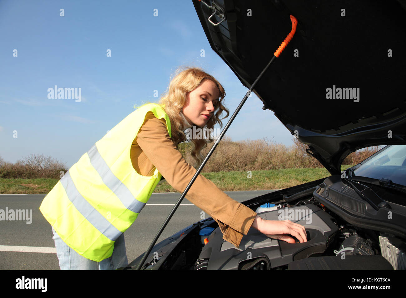 Woman checking on car engine breakdown Stock Photo - Alamy