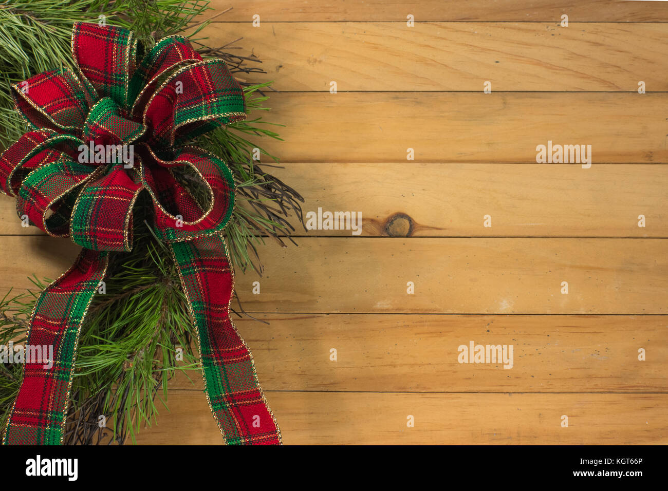 A beautiful handmade bow of red, green, and gold trimmed ribbon on a ...