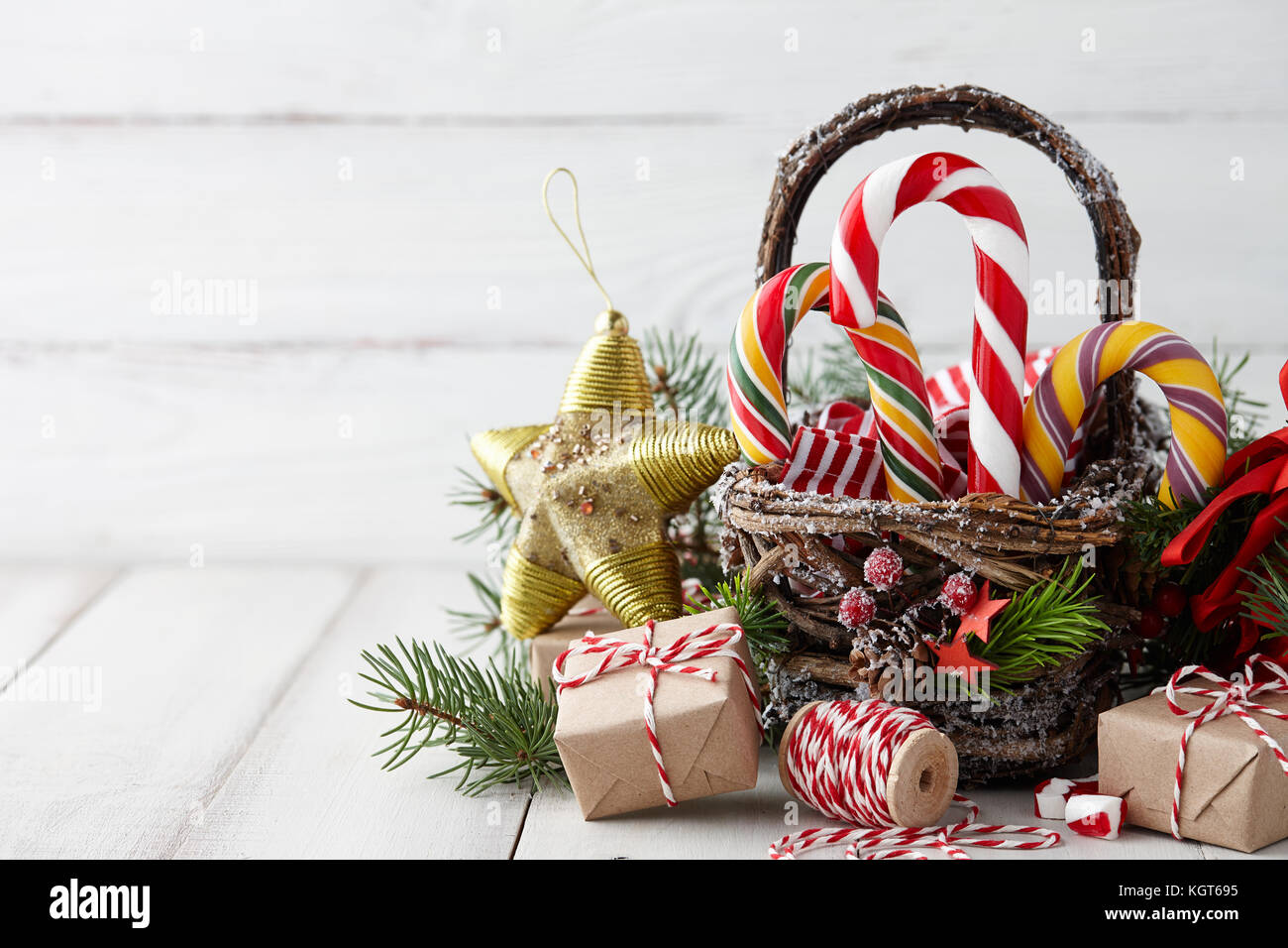 Christmas basket with candy canes on white planks Stock Photo - Alamy
