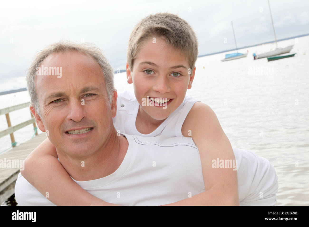 Portrait of man carrying young boy on his back Stock Photo - Alamy
