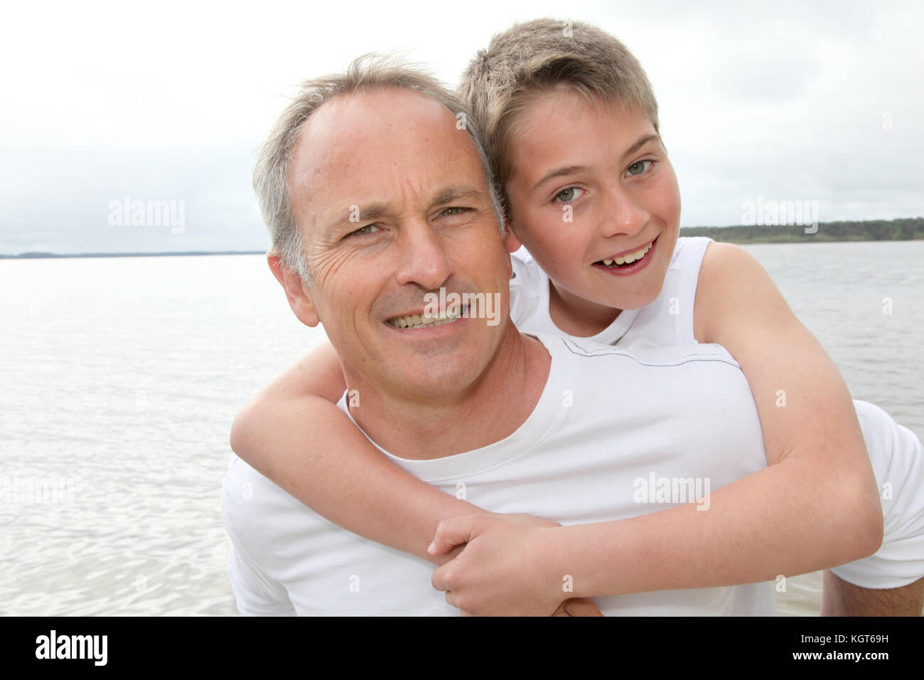 Portrait of man carrying young boy on his back Stock Photo - Alamy