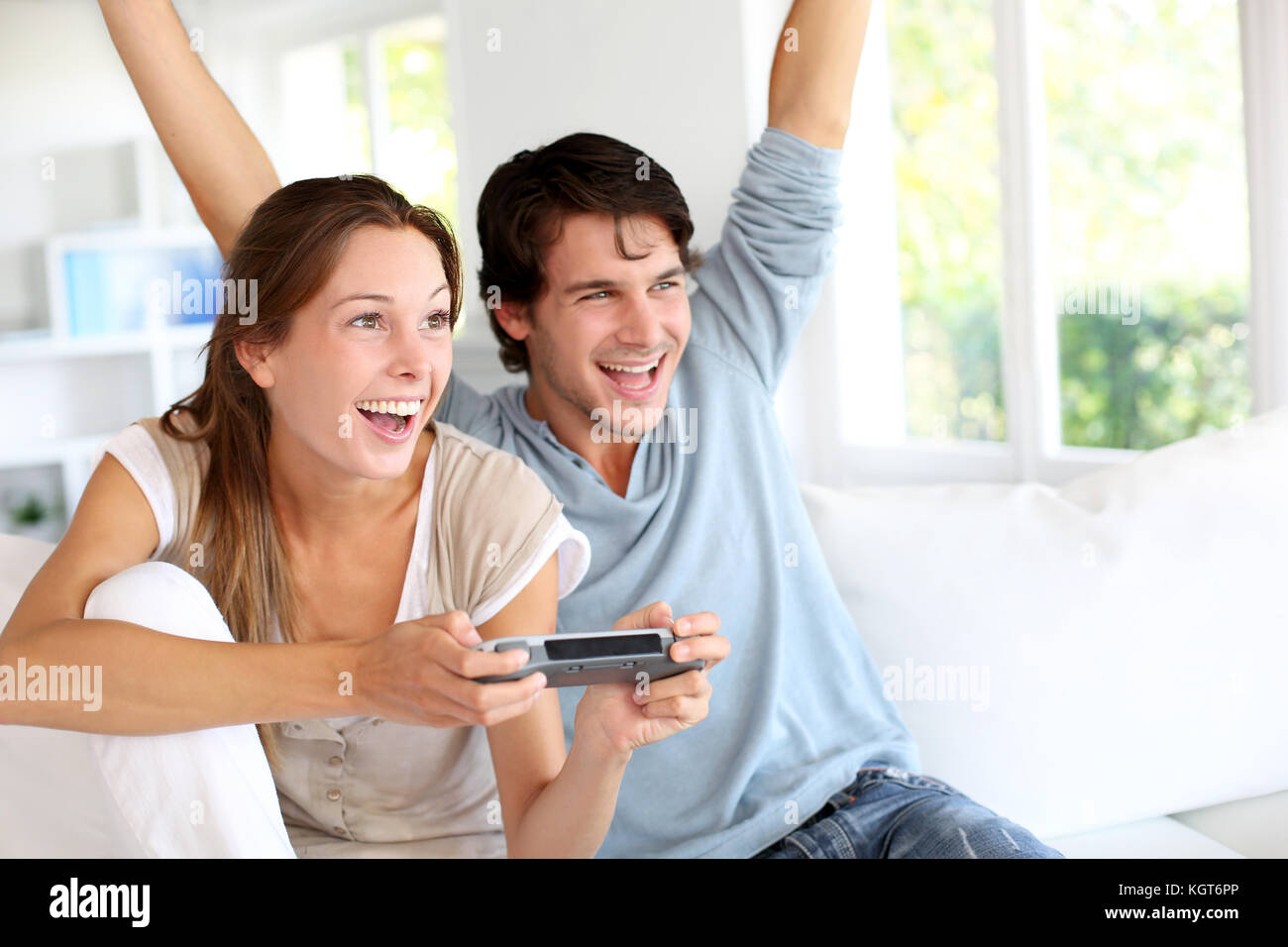 Young couple playing video games at home Stock Photo - Alamy