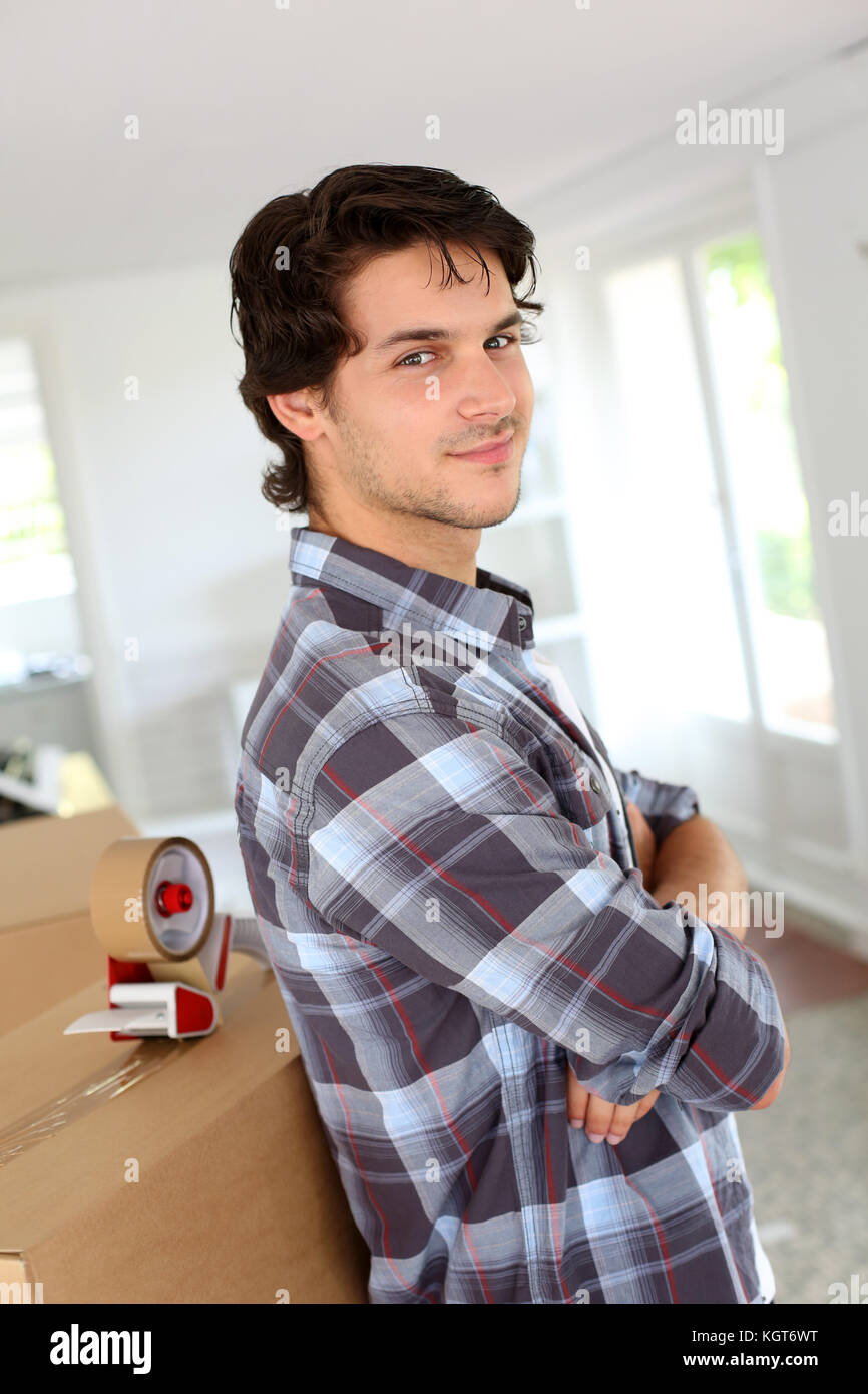 Young man packing boxes to move in new flat Stock Photo - Alamy
