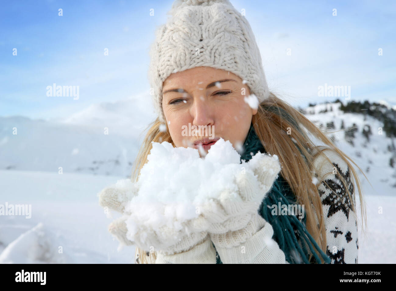 Woman blowing snow flakes towards camera Stock Photo - Alamy