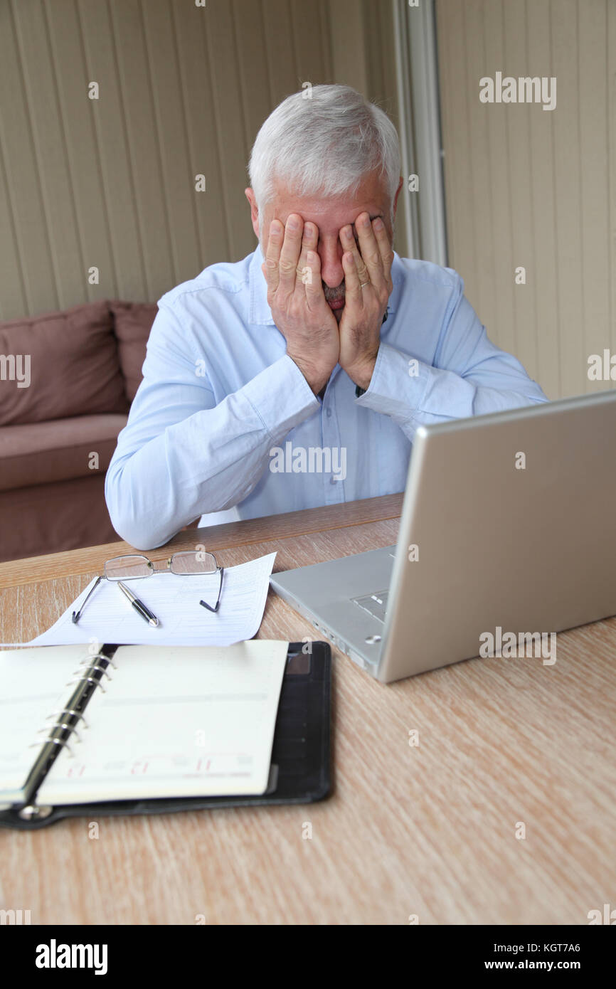 Desperate senior man in front of laptop computer Stock Photo - Alamy