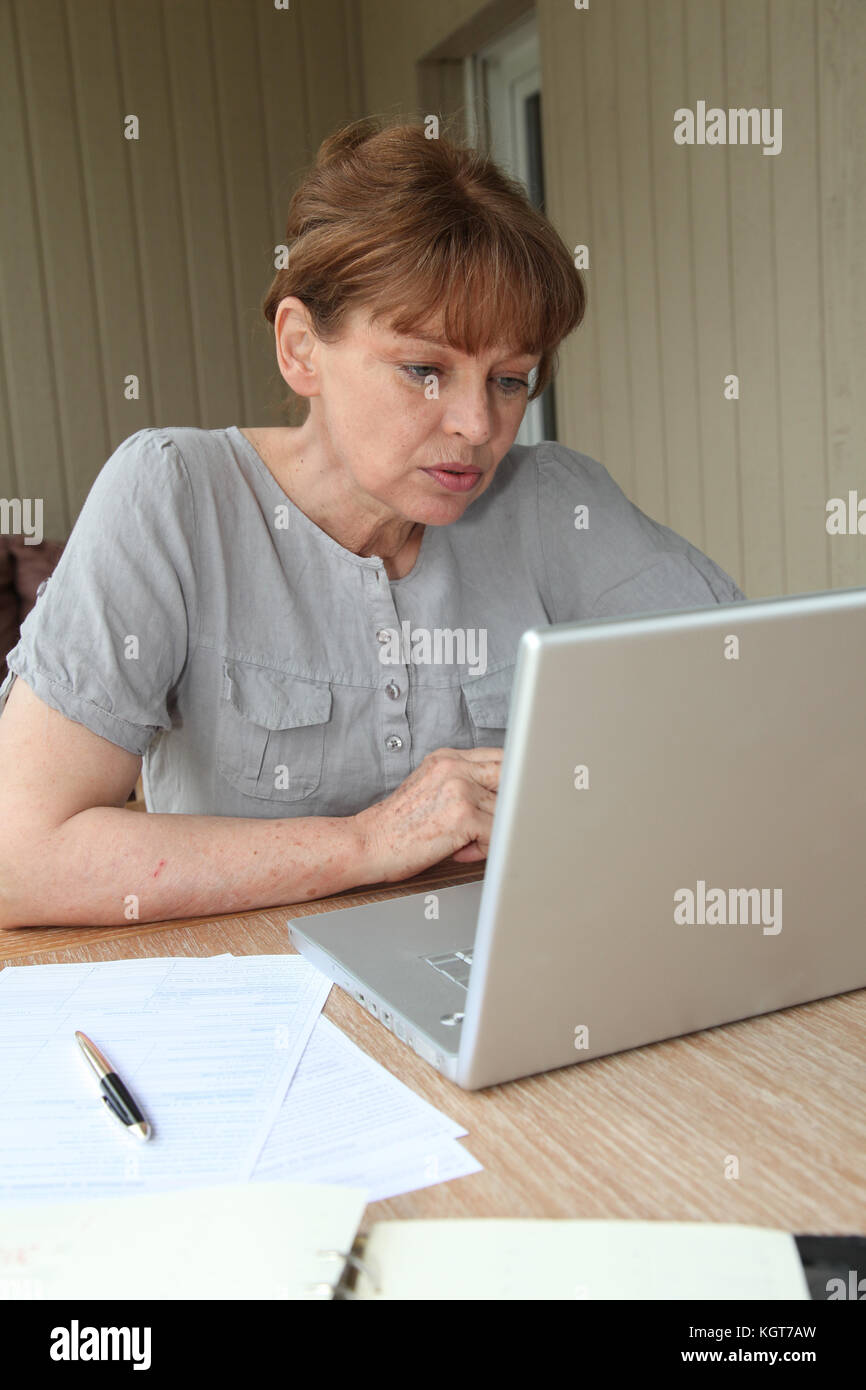 Senior woman filling out form with help of internet Stock Photo - Alamy